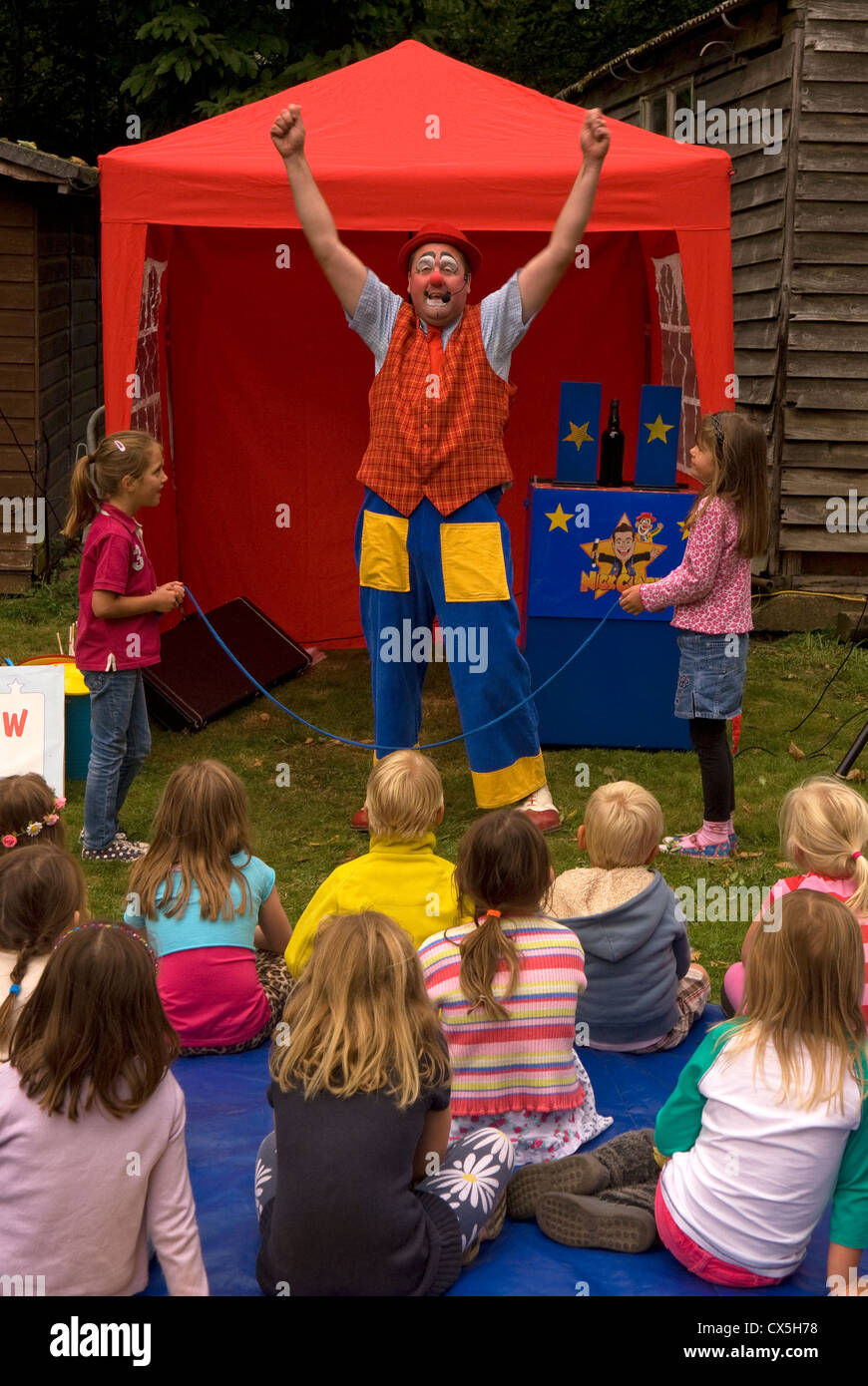 Clown entertaining youngsters at a children's outdoor fun day, Liphook ...