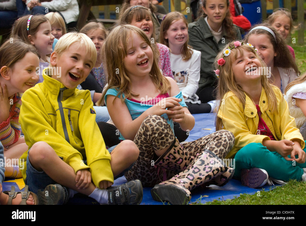 Youngsters being entertained by a clown at a children's outdoor fun day ...