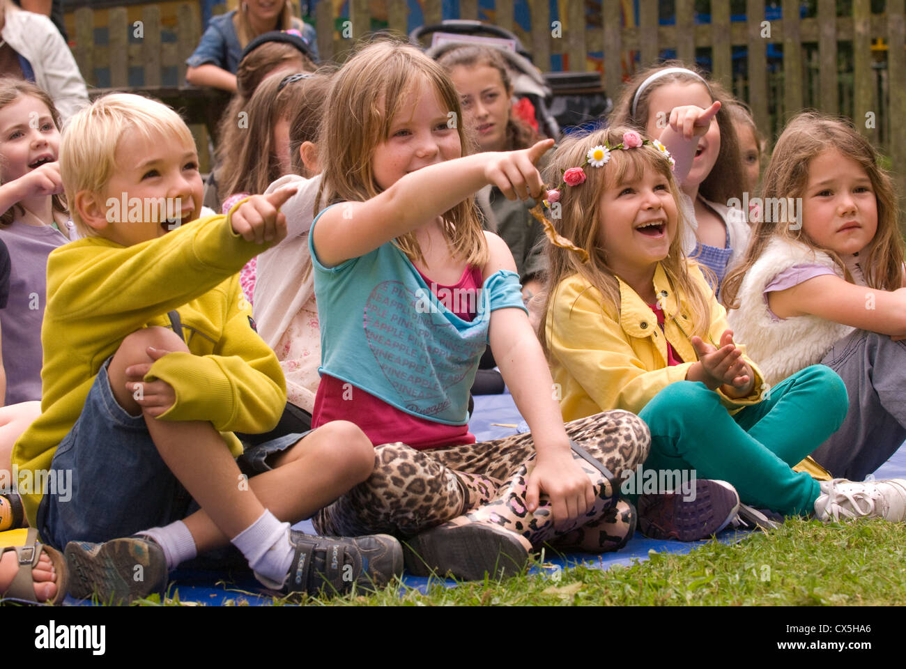 Youngsters being entertained by a clown at a children's outdoor fun day ...