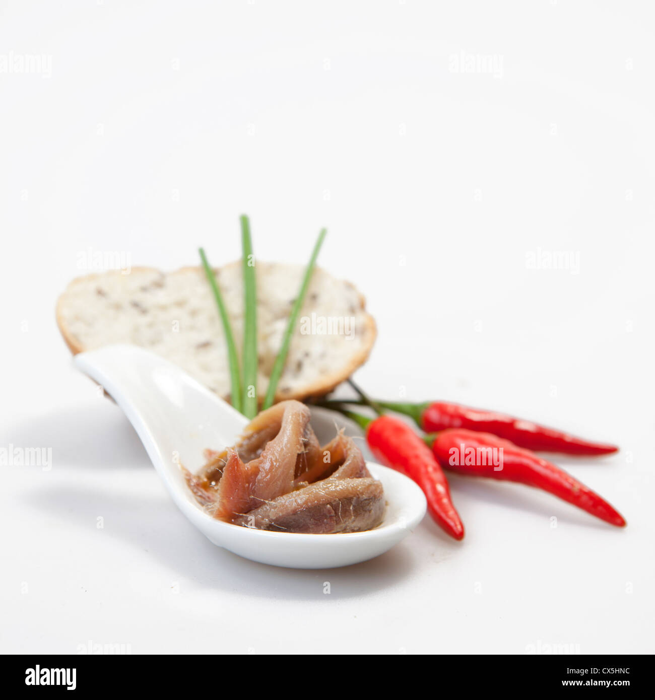 Delicious salted anchovies with oil on white background Stock Photo - Alamy