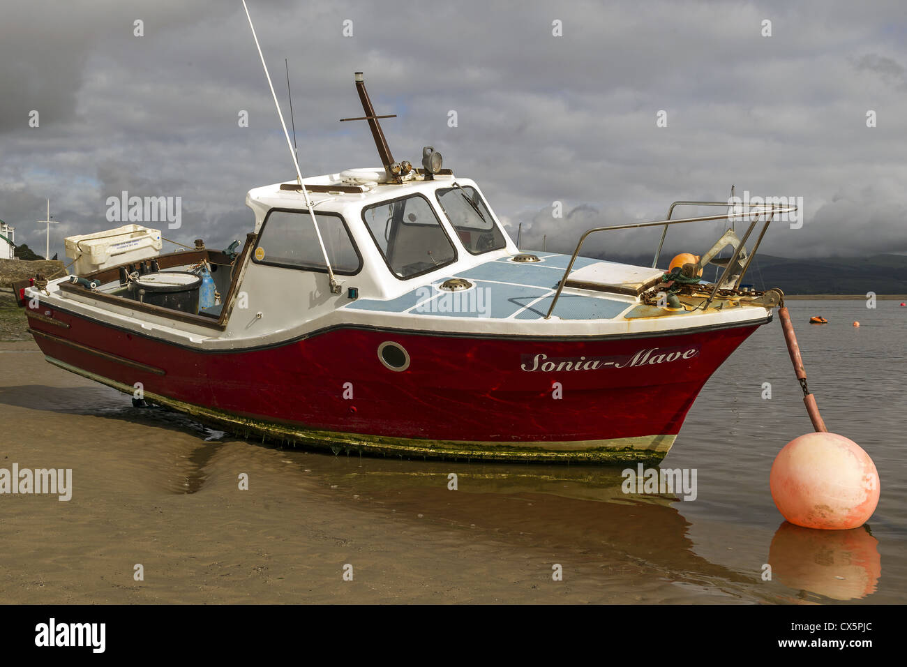small boat on buoy at waters edge Stock Photo - Alamy