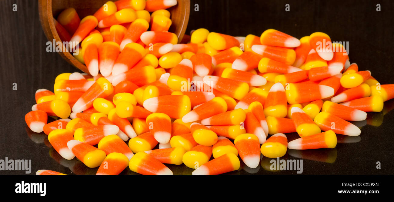 Candy corn sweets spilling onto table Stock Photo - Alamy
