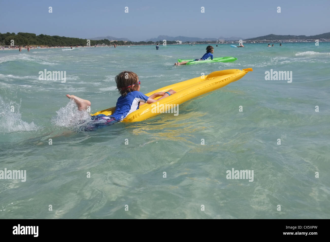 young boys play on beach in the waves on inflatable lilos Stock Photo ...