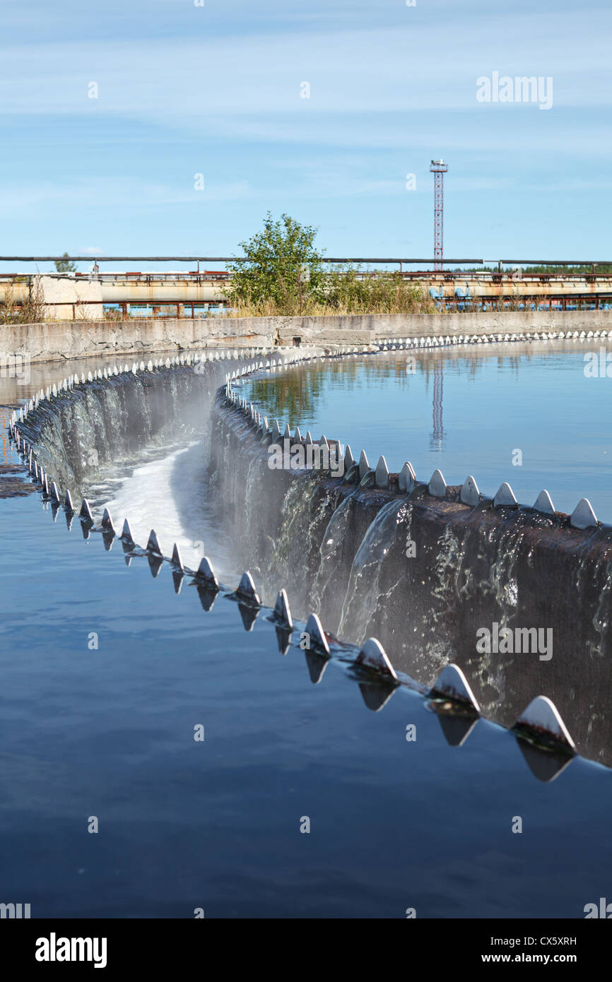 Close up of water overflowing from circular storage tank. Sewage ...