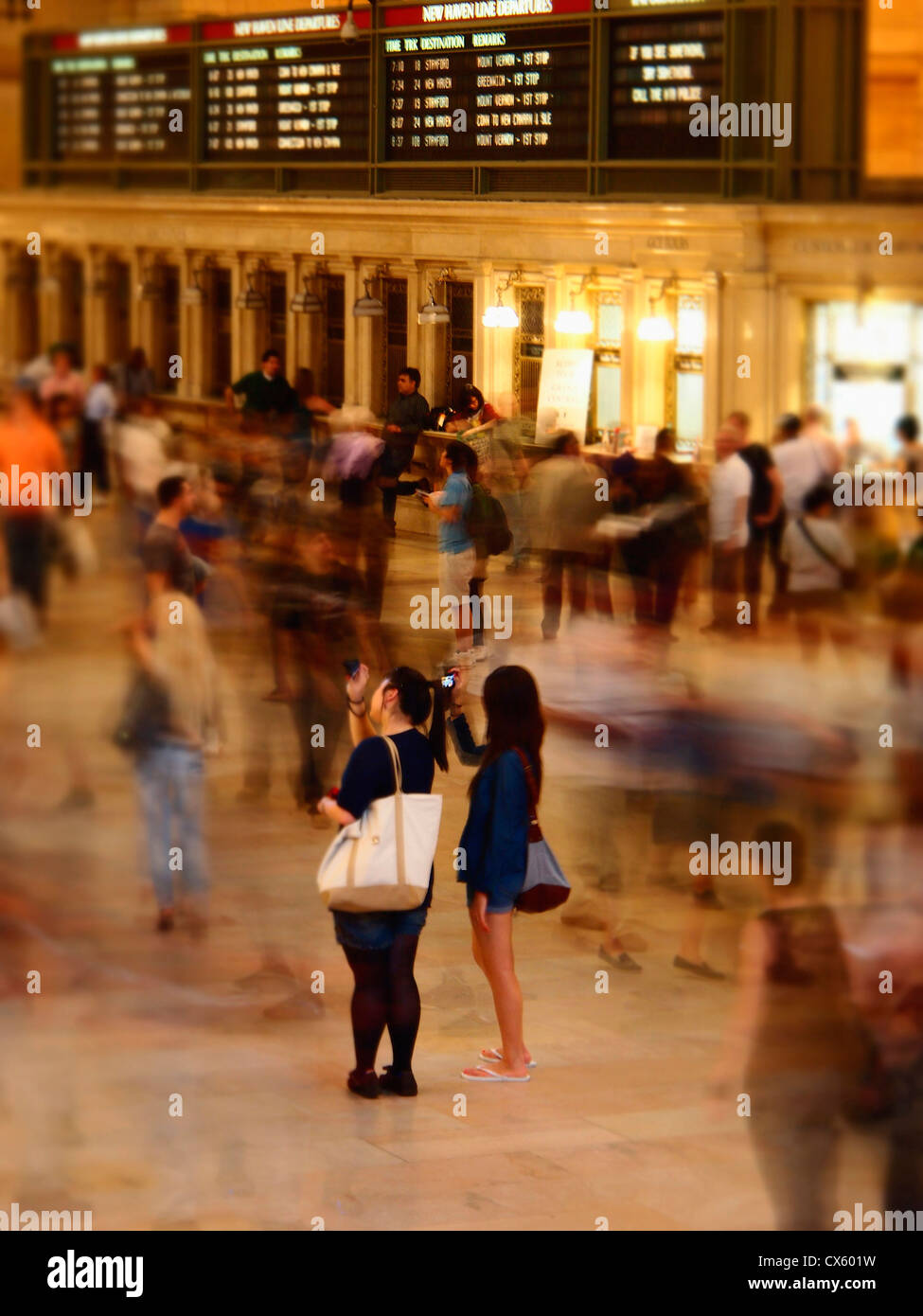 Two tourists photograph bustling crowds in Grand Central Station, NYC ...