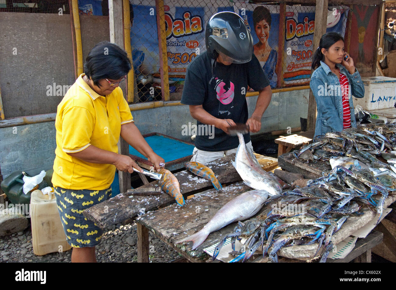 A fish stand with vendors cleaning the fish at the local market in ...