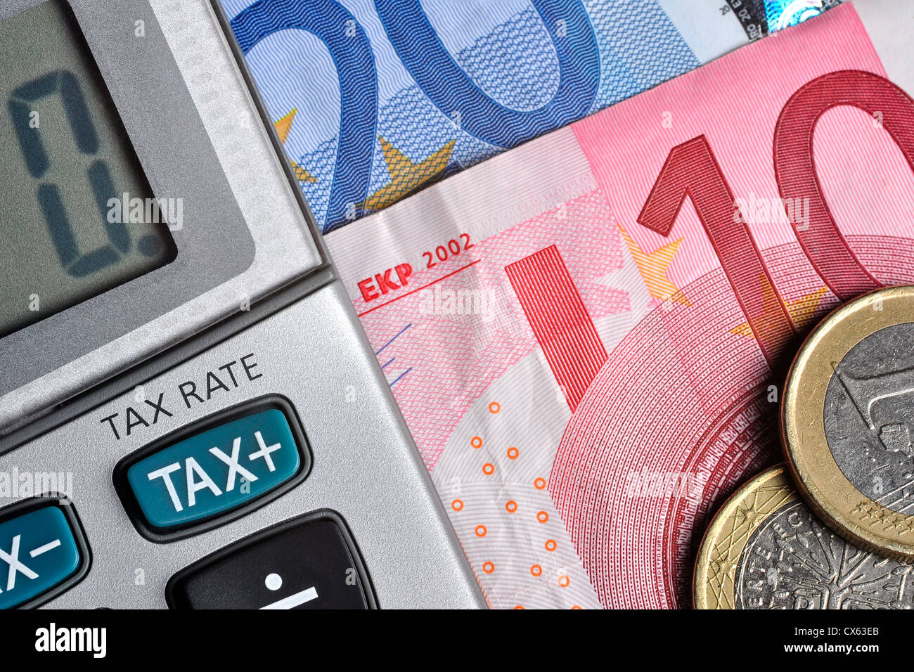 Detail of calculator, focusing the TAX key, next to some Euro bills and ...