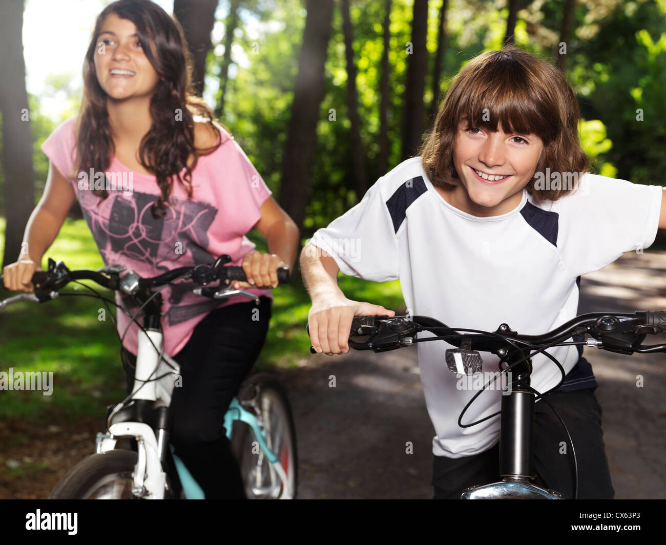 Two happy smiling children riding bicycles in a park, brother and ...