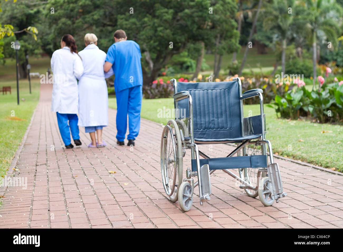 caring doctor and nurse helping senior patient get up from wheelchair ...
