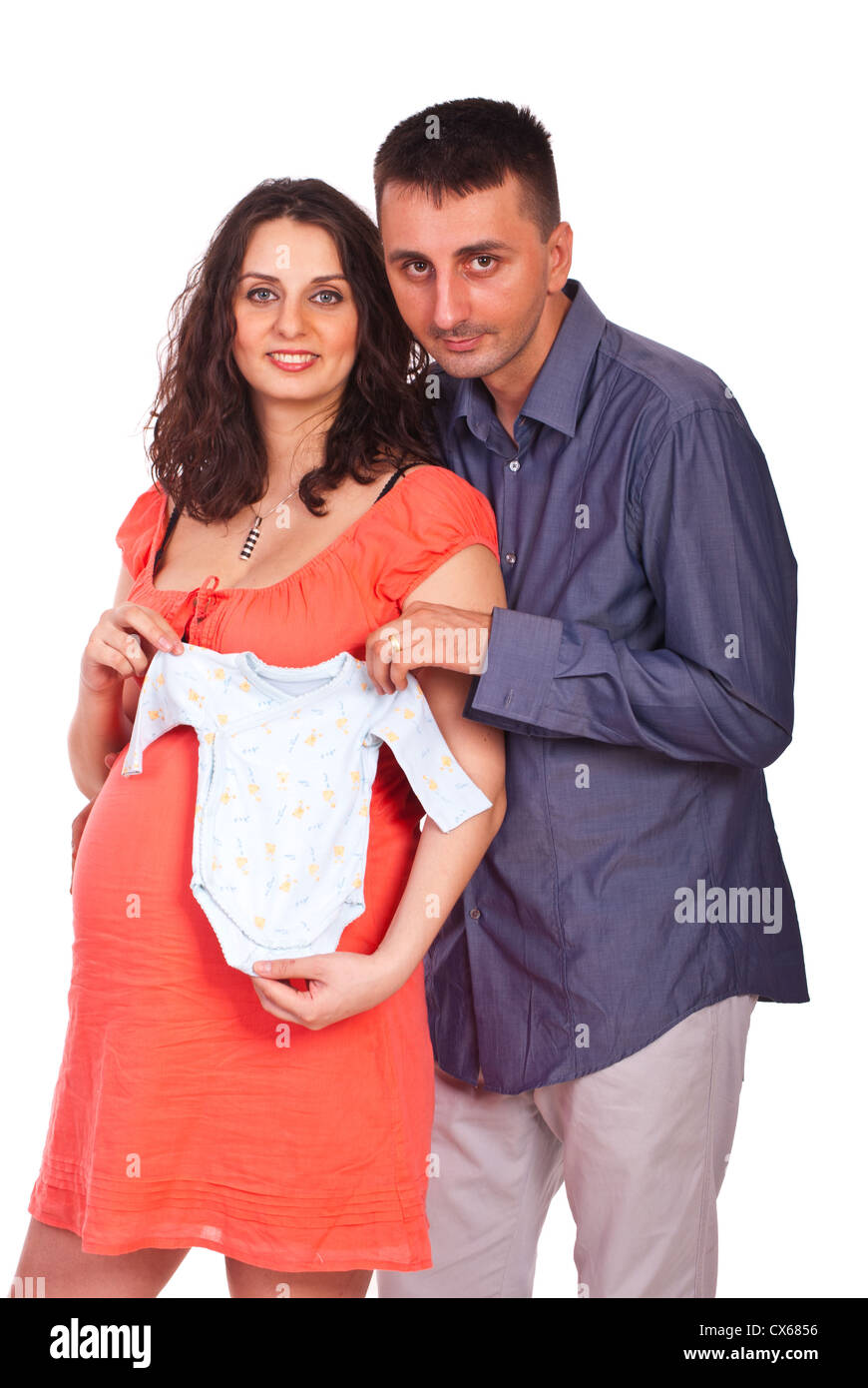 Happy future parents showing baby cloth isolated on white background ...