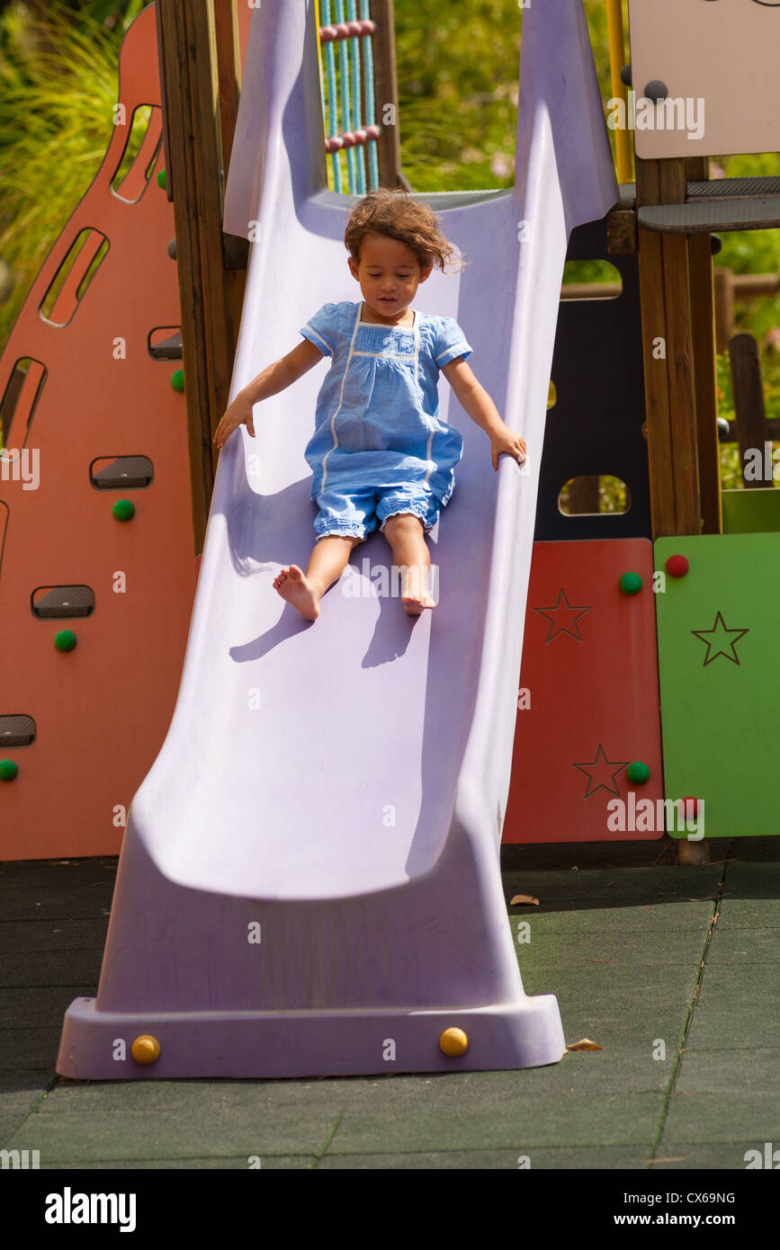 Joy sliding down a chute for a small Hispanic girl Stock Photo - Alamy