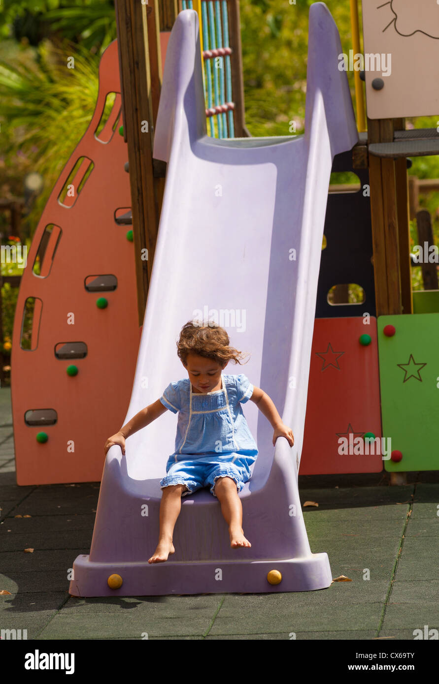 Small Hispanic girl sliding down a chute Stock Photo - Alamy