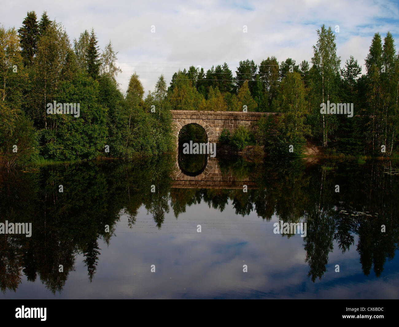 Trees and old bridge are reflecting in the lake Stock Photo - Alamy