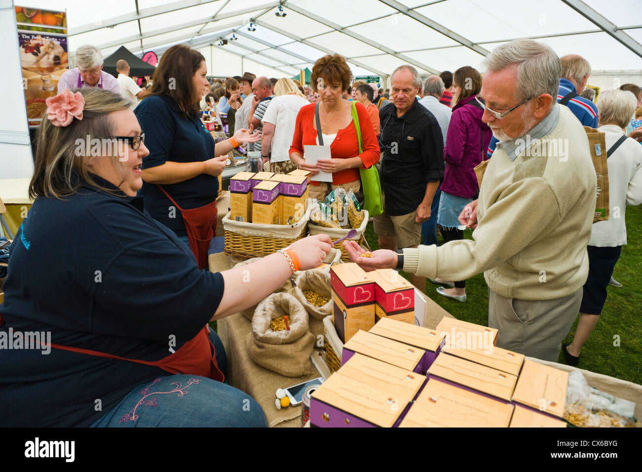Visitors sampling Granola cereal on stall at Ludlow Food Festival 2012 ...