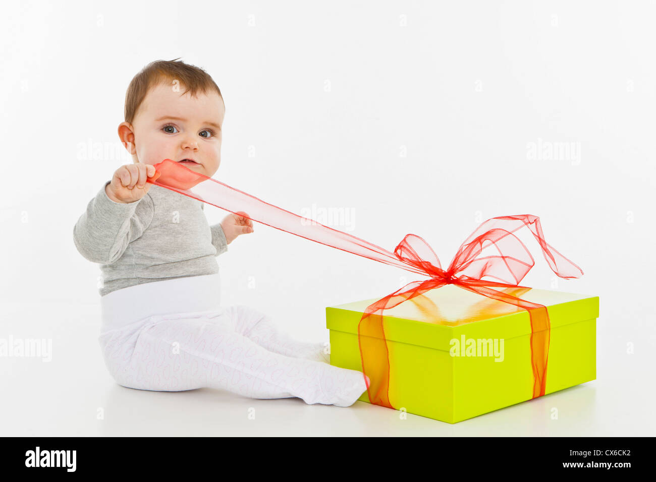 A baby girl opening a present Stock Photo - Alamy