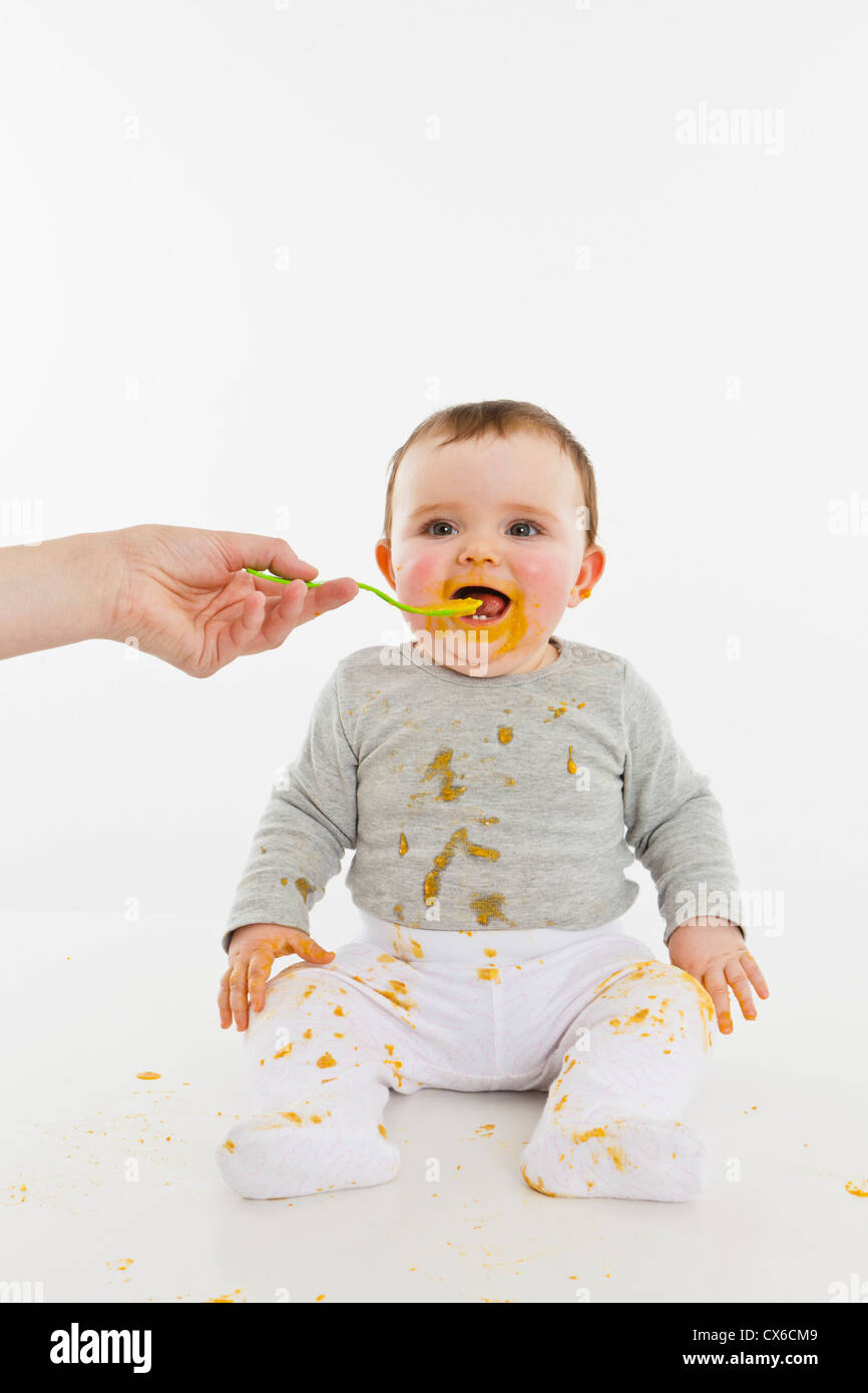 An adult feeding a baby Stock Photo - Alamy