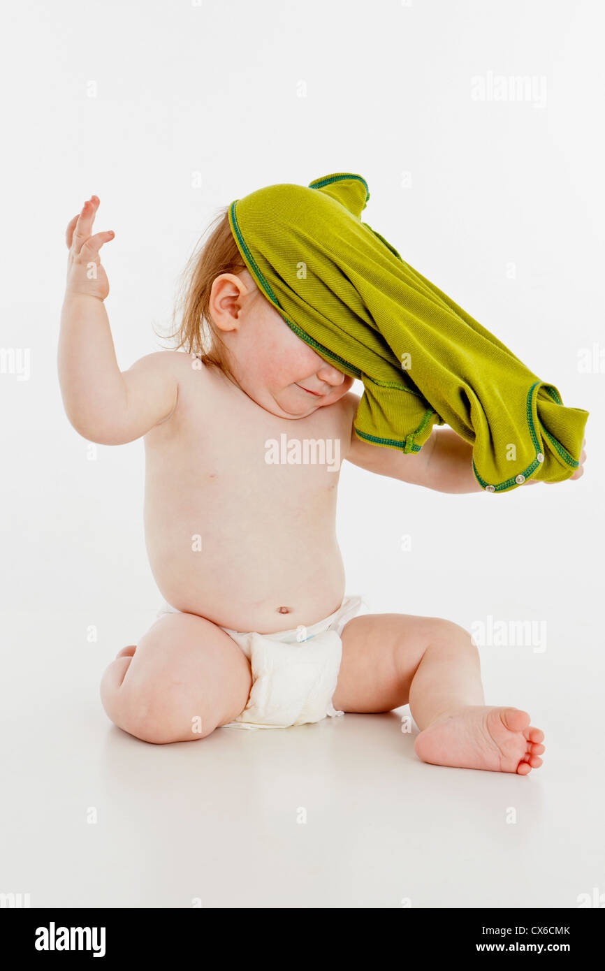 A baby girl pulling her shirt off Stock Photo - Alamy