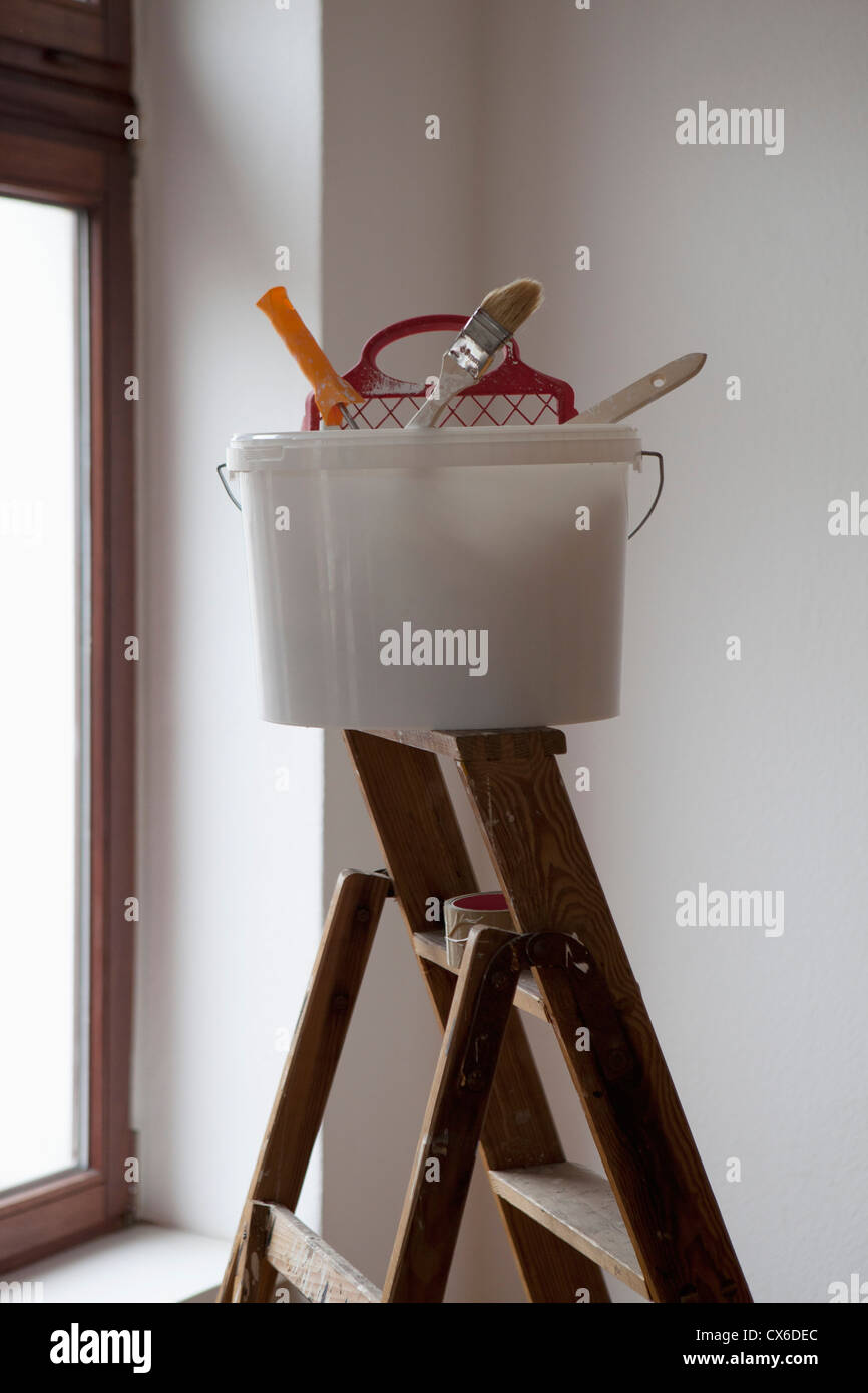 A bucket of painting equipment on a ladder Stock Photo - Alamy