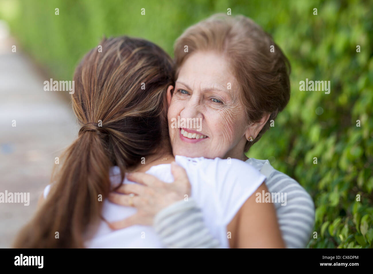 A senior woman hugging a young woman Stock Photo - Alamy