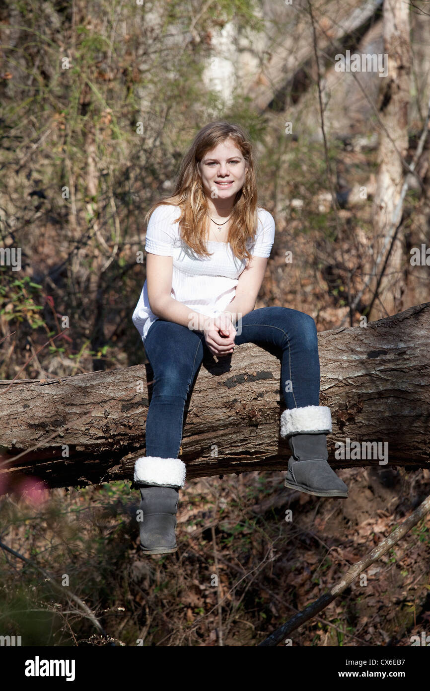 Girl sitting on tree trunk in Mooresville, North Carolina, USA Stock ...