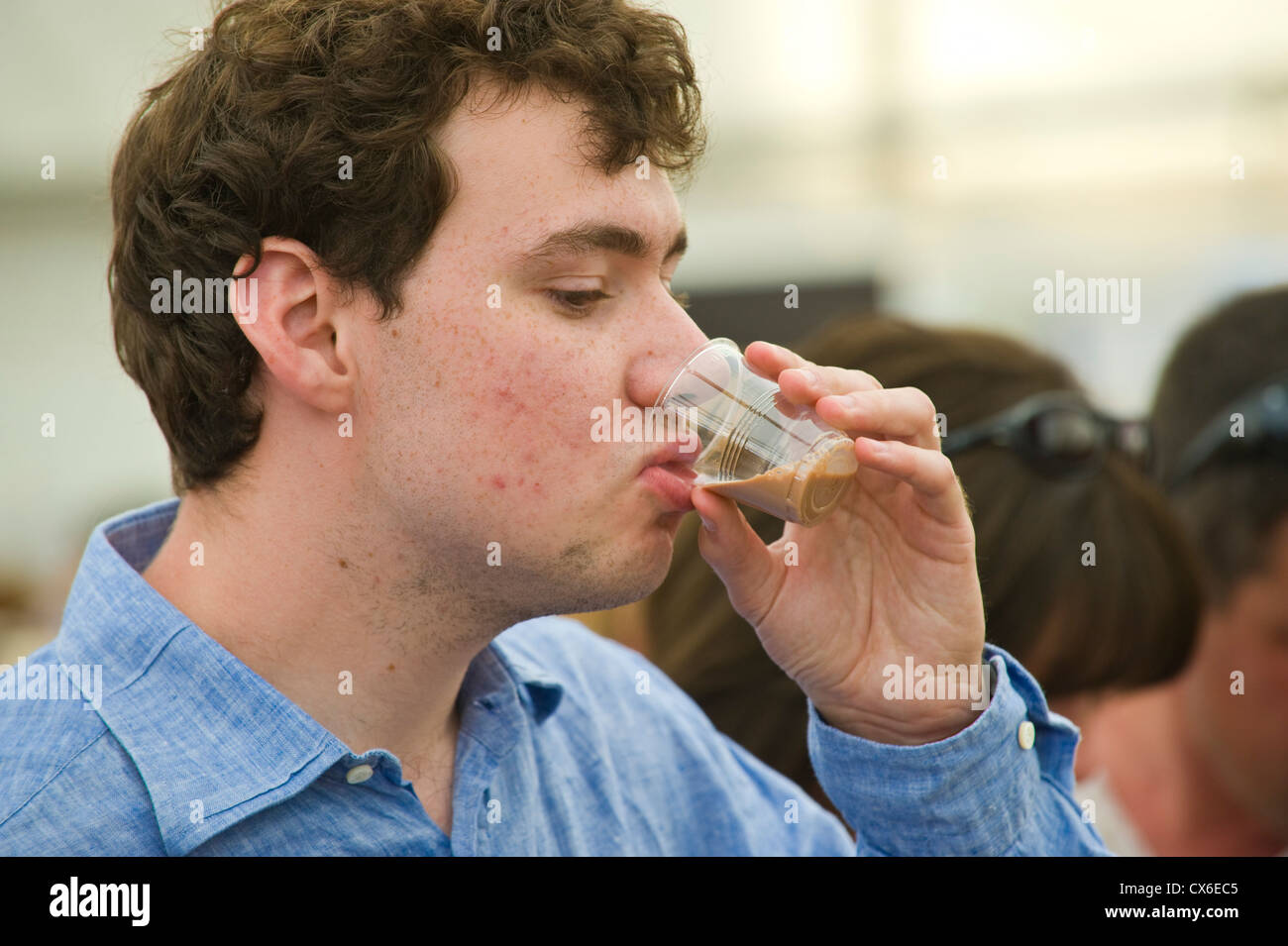 Visitor sampling chocolate drink on stall at Ludlow Food Festival 2012 ...