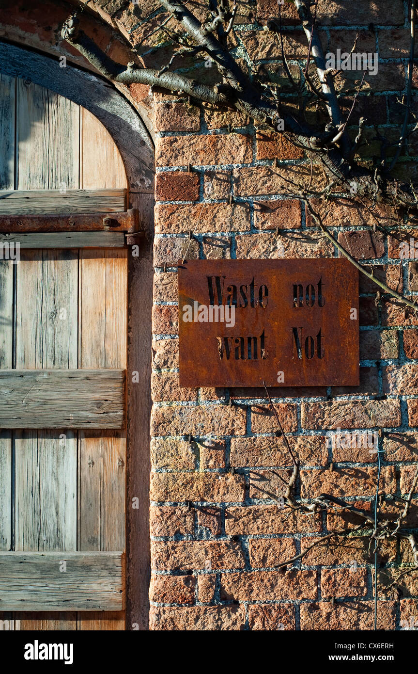 'Waste Not Want Not' wooden plaque on stone wall Stock Photo - Alamy