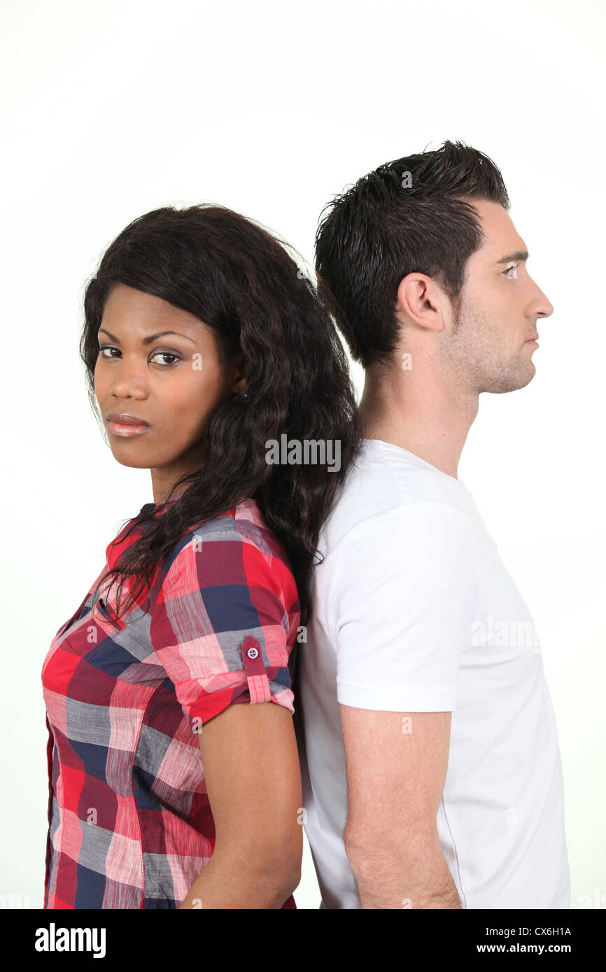 Couple standing back to back Stock Photo - Alamy