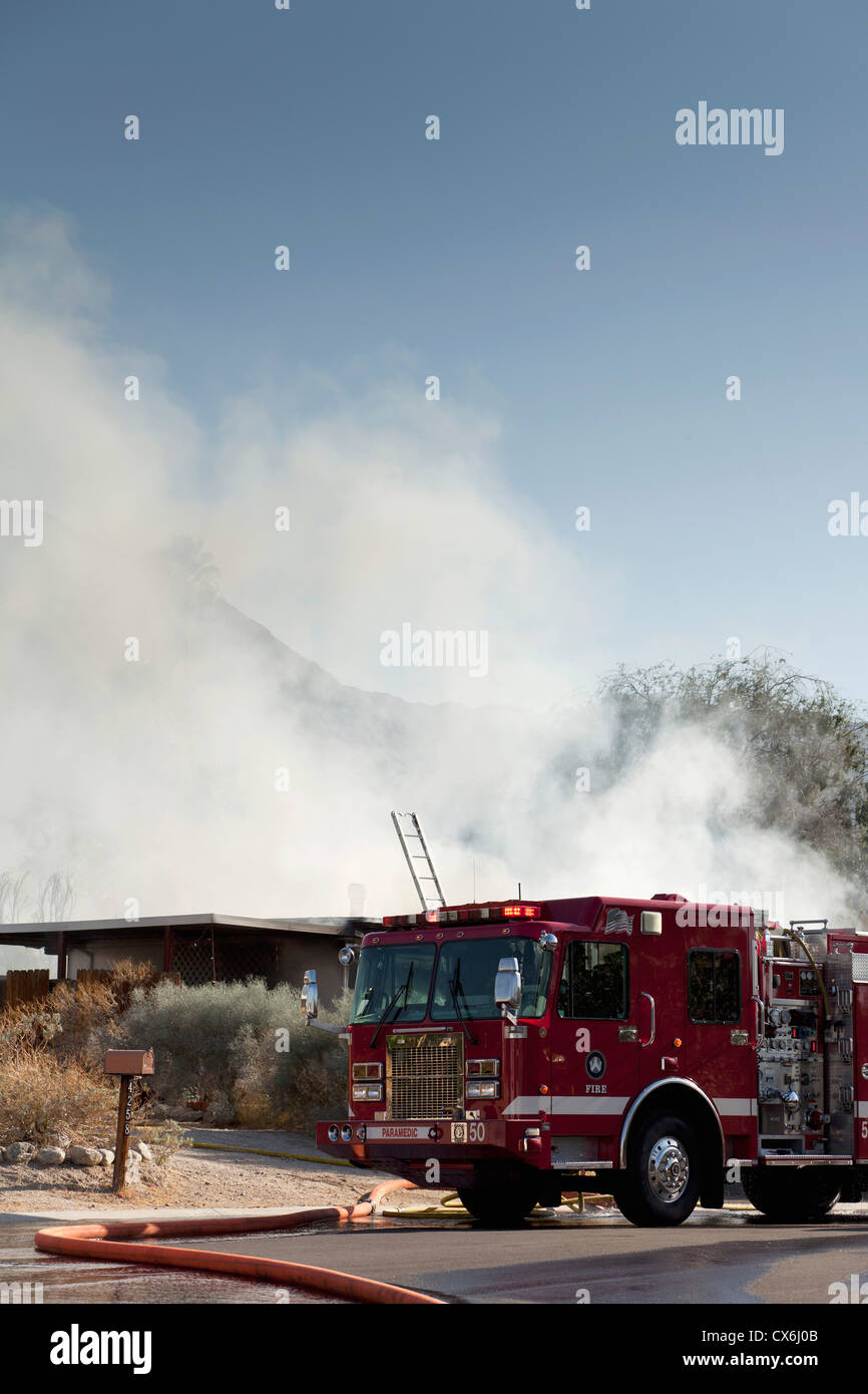 A fire truck next to a burning house in a suburb Stock Photo - Alamy
