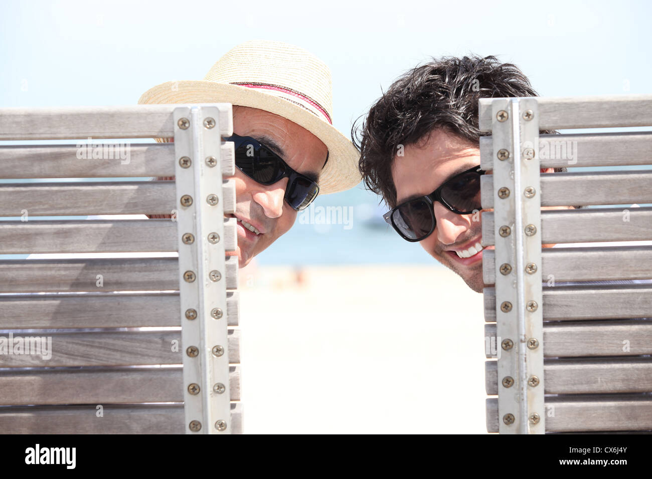 Two friends sat on deckchairs at the beach Stock Photo - Alamy