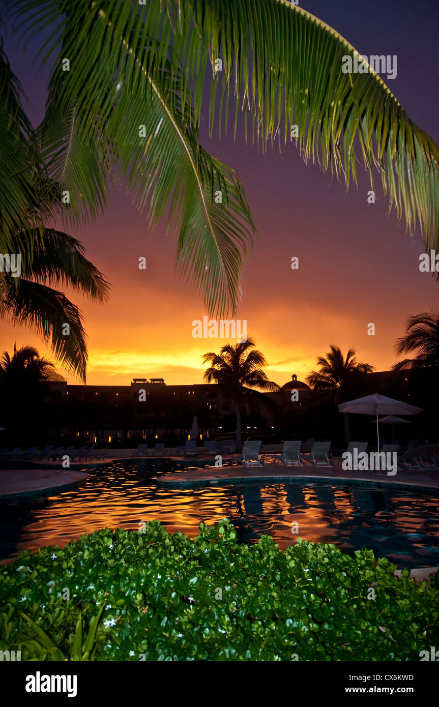 A tropical sunset lights up the sky and pool at the Hacienda Tres Rios ...