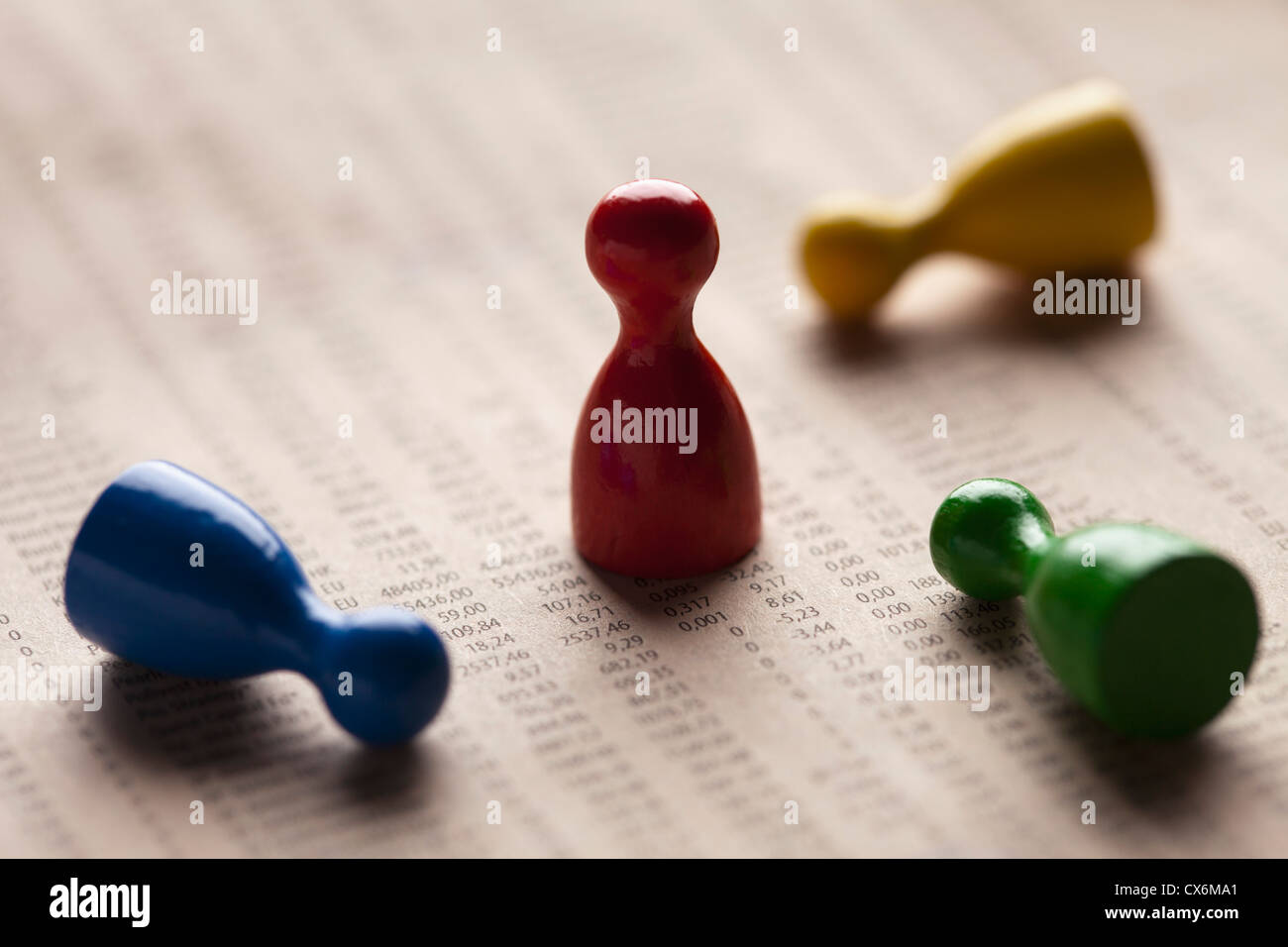 Three game pieces knocked over surrounding a standing red piece Stock ...