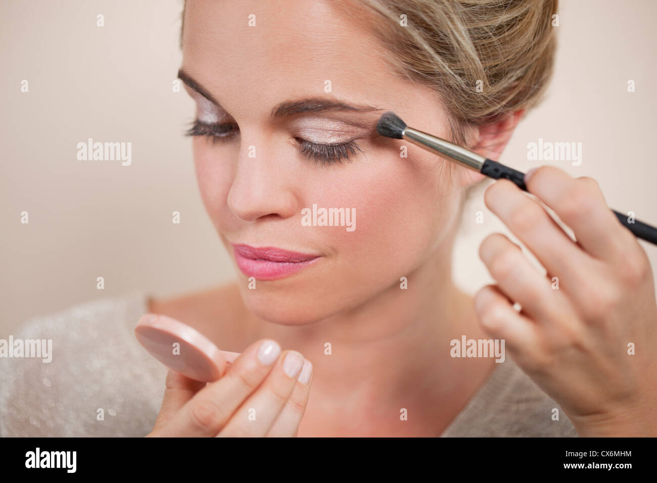 A young woman applying eye makeup Stock Photo - Alamy