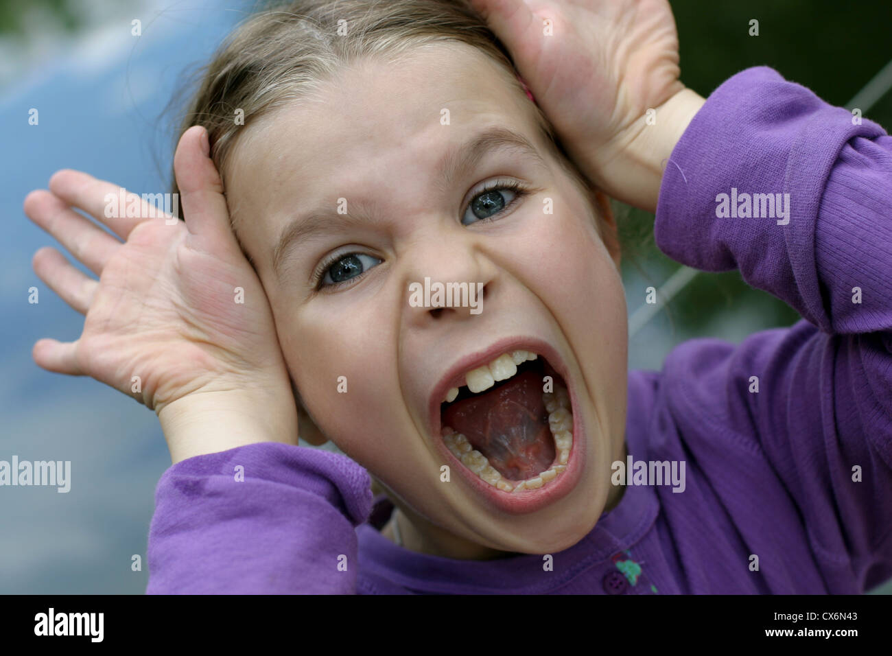 Screaming girl with hands raised beside her face Stock Photo - Alamy