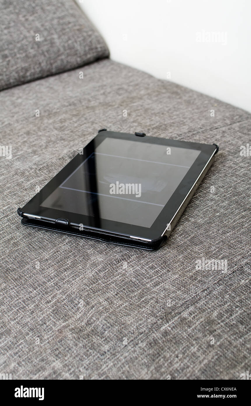 Tablet computer laying on the sofa Stock Photo - Alamy