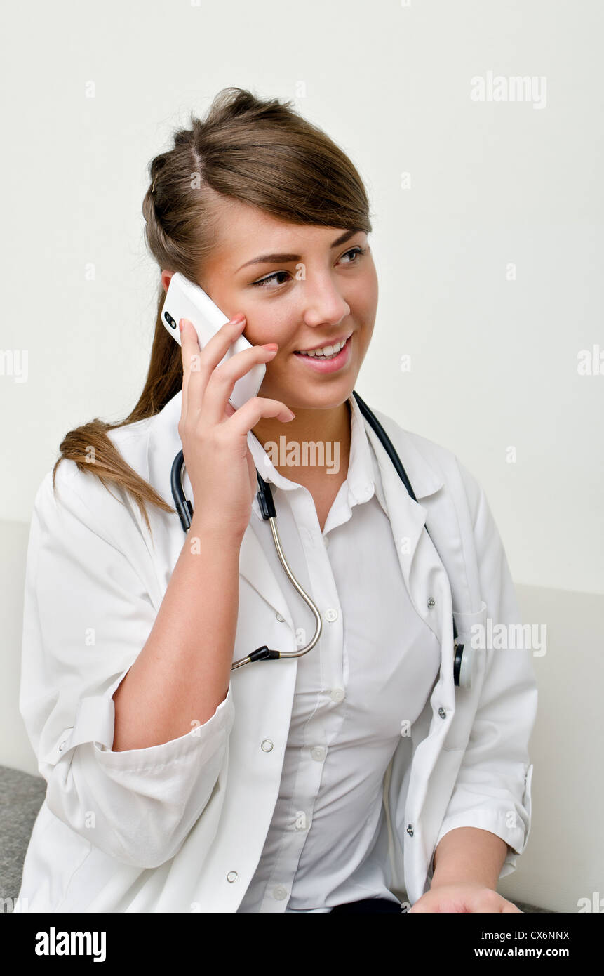 Young female doctor talking on phone Stock Photo - Alamy