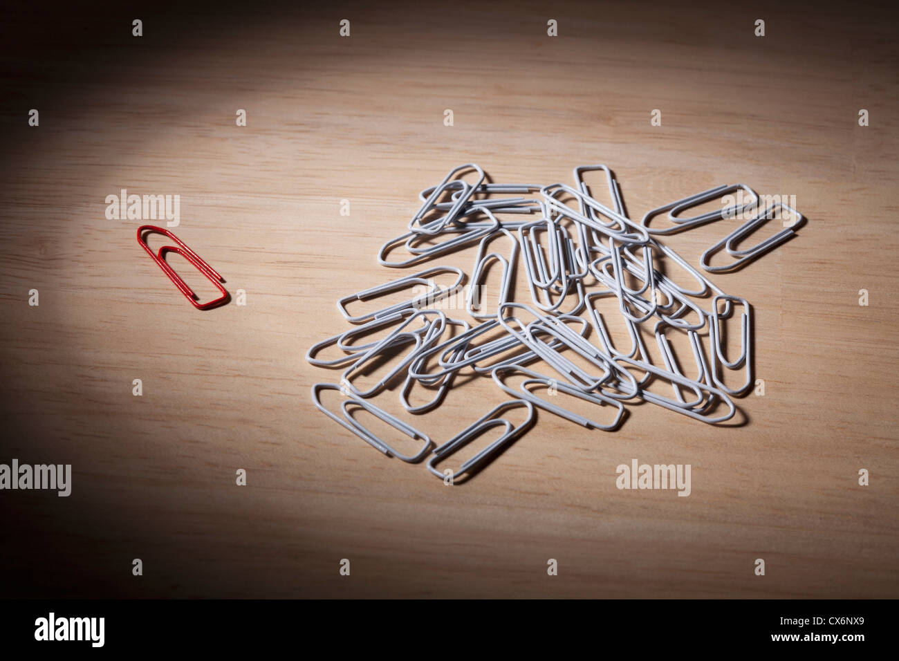 One red paperclip set apart from a heap of white paperclips Stock Photo ...