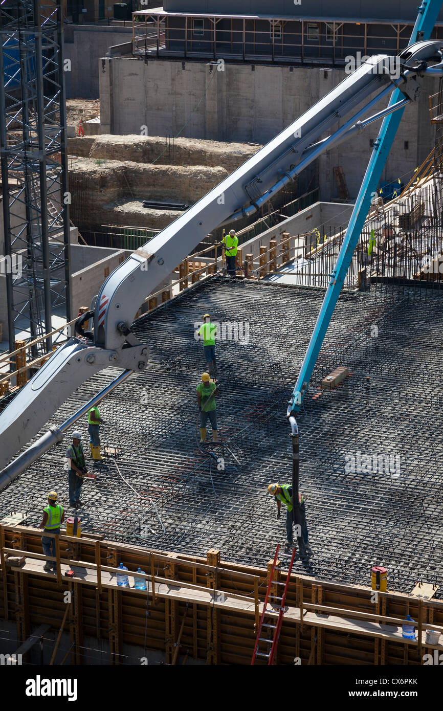 Construction workers pouring cement at construction site Stock Photo ...