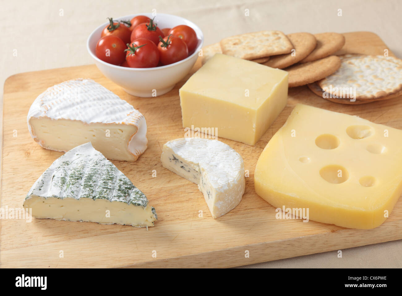 A cheeseboard with Jarlsberg, Cheddar, herbed Brie, Camembert and St ...