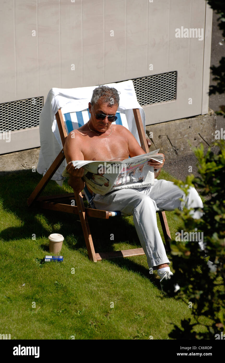 Man sunbathing in a deck chair in Bath Somerset UK Stock Photo - Alamy