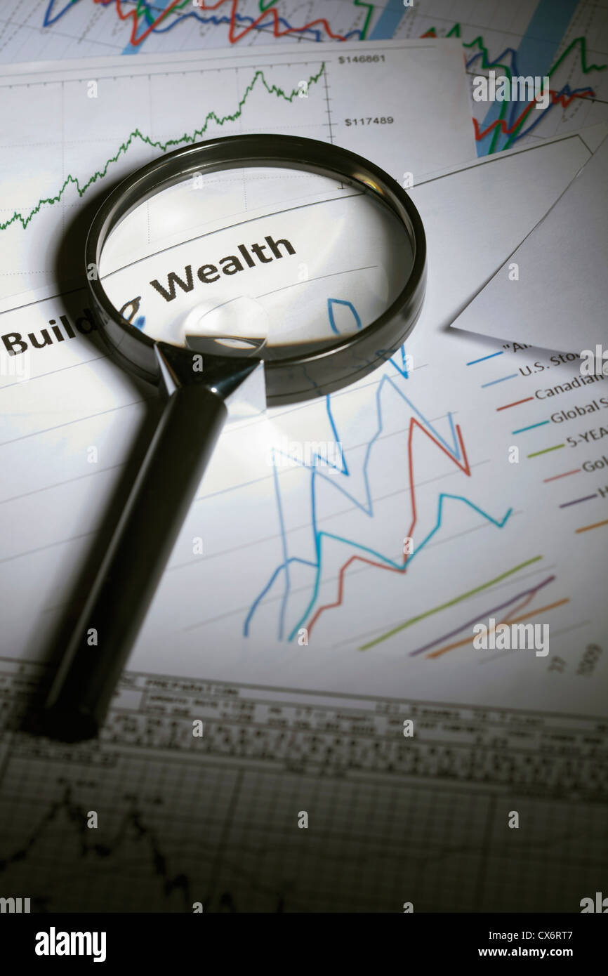 Financial paperwork with a magnifying glass on top Stock Photo - Alamy