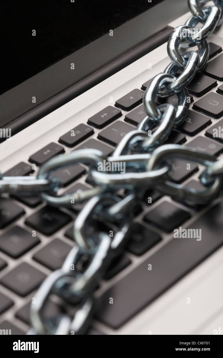 A thick metal chain wrapped around a laptop, close-up Stock Photo - Alamy