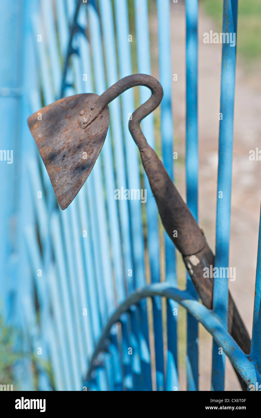 A garden hoe leaning on a gate Stock Photo - Alamy