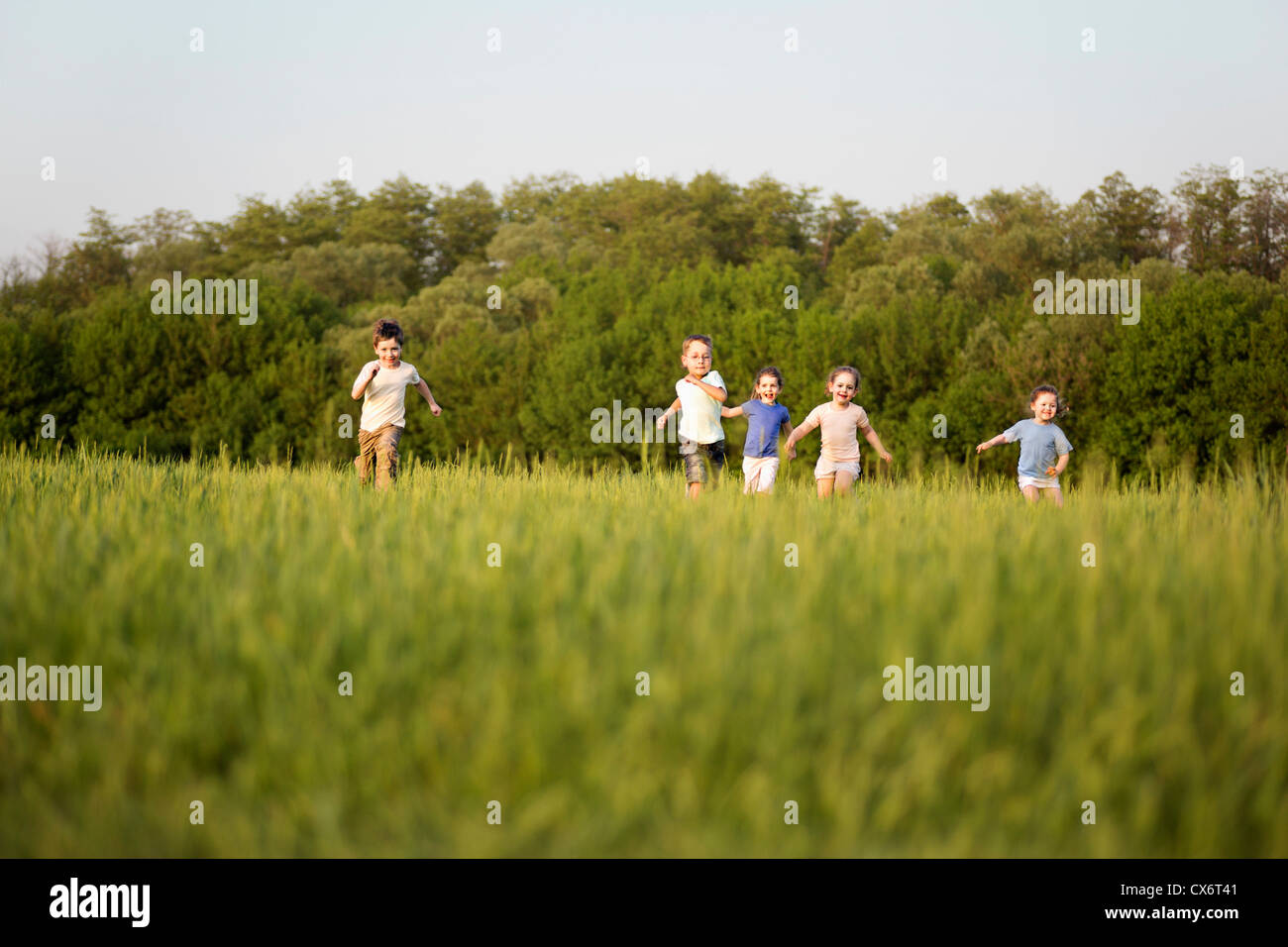 Children running in a field Stock Photo - Alamy