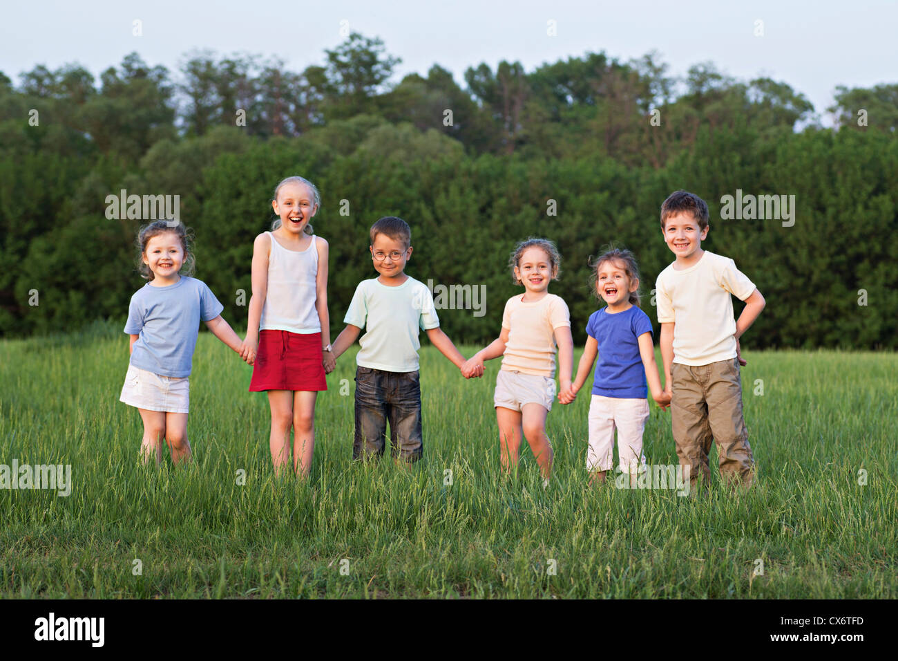 Children holding hands and standing in a field Stock Photo - Alamy
