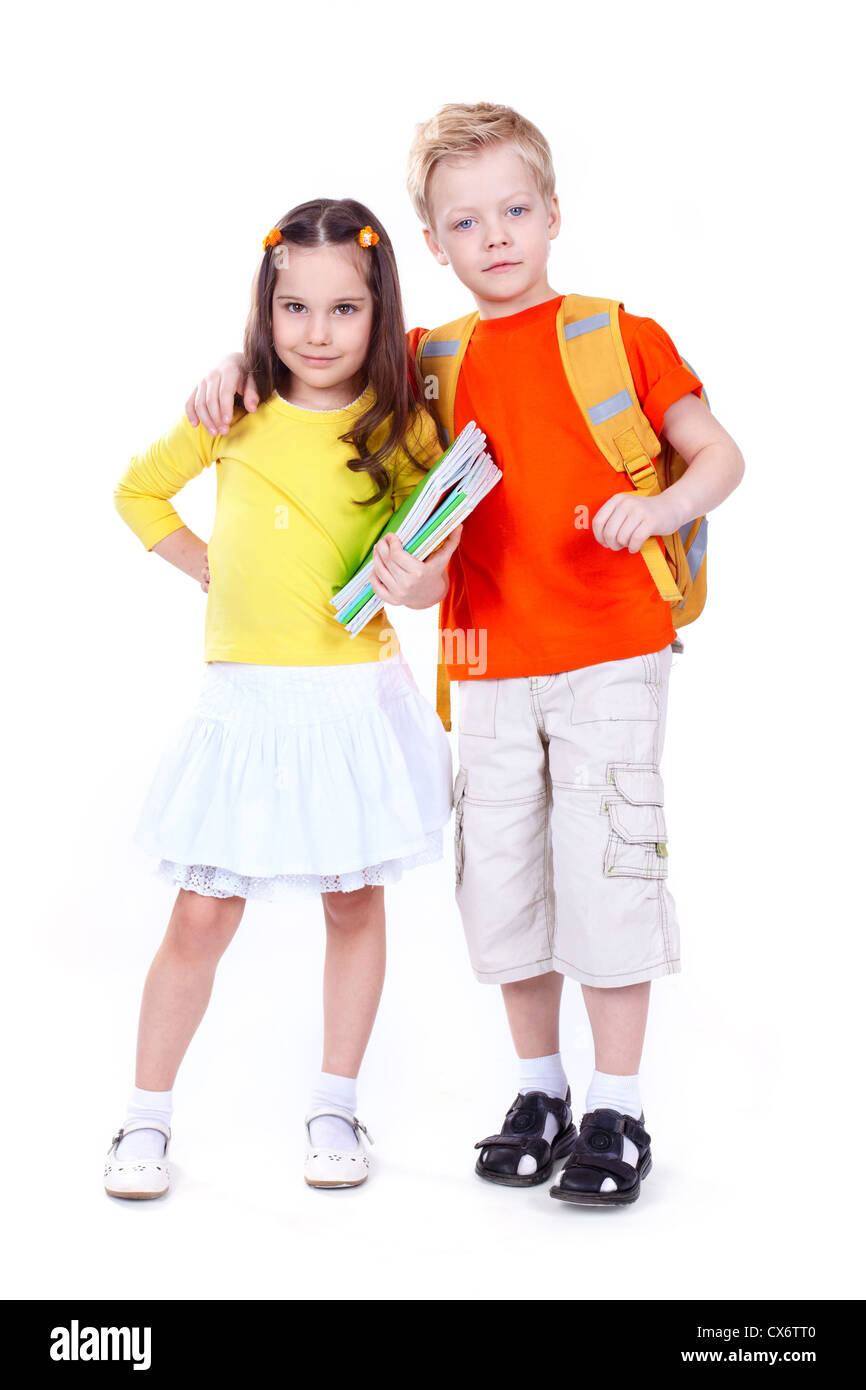 Two school children isolated on white background looking confidently at ...