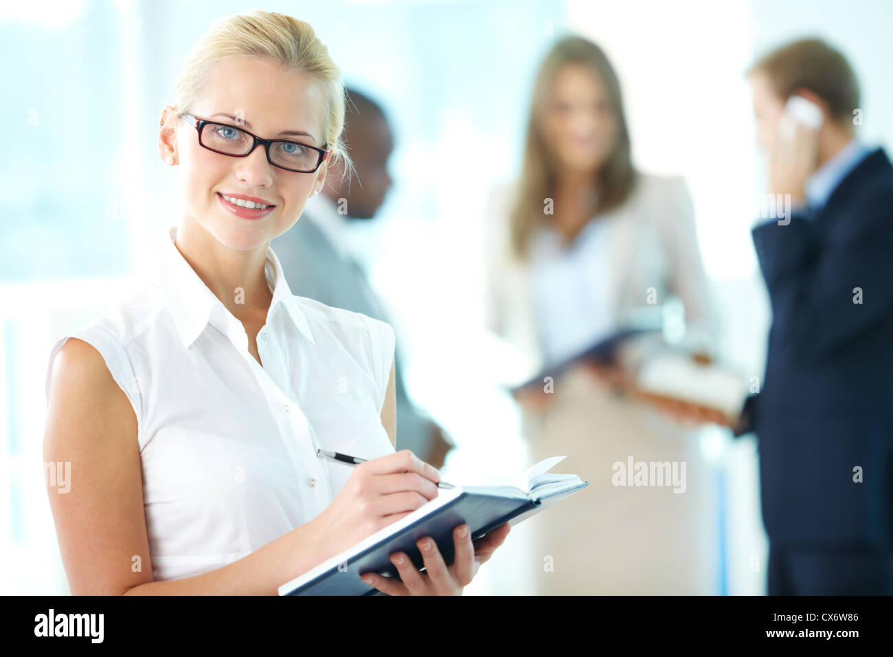 Portrait of busy secretary looking at camera Stock Photo - Alamy