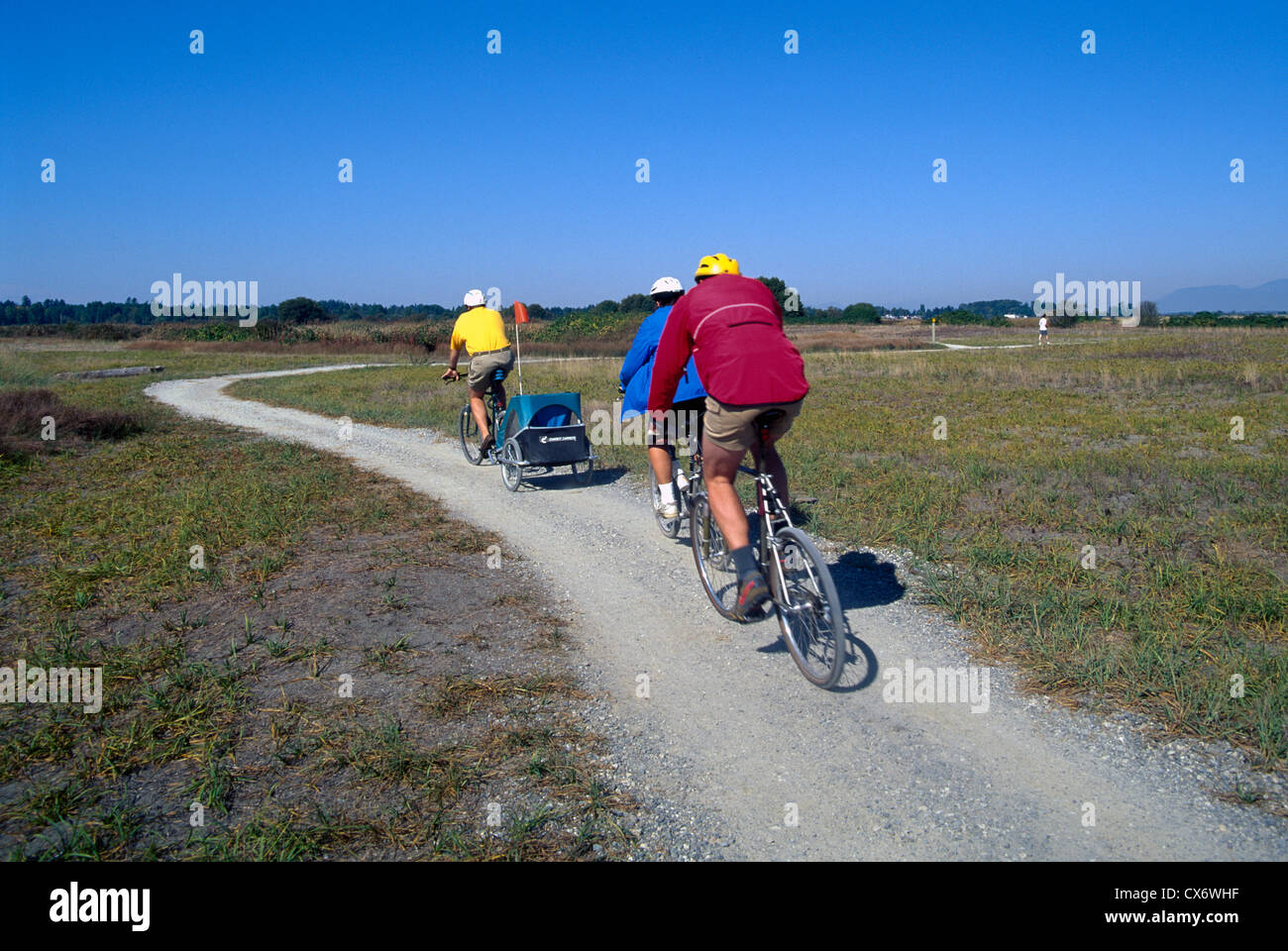 Family cycling Single File on a Gravel Path, Boundary Bay Regional Park ...