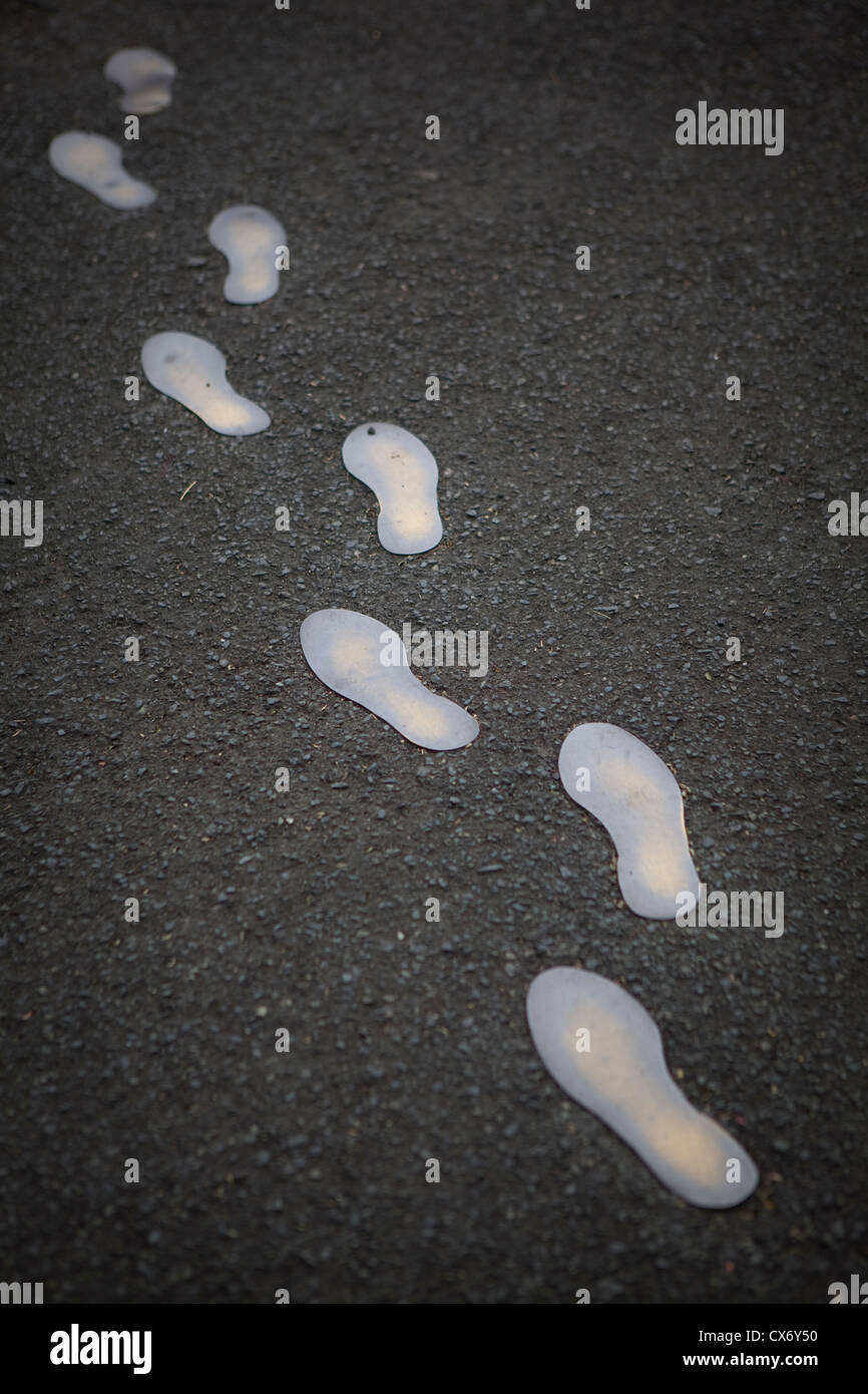 A white footprint path on a black street Stock Photo - Alamy