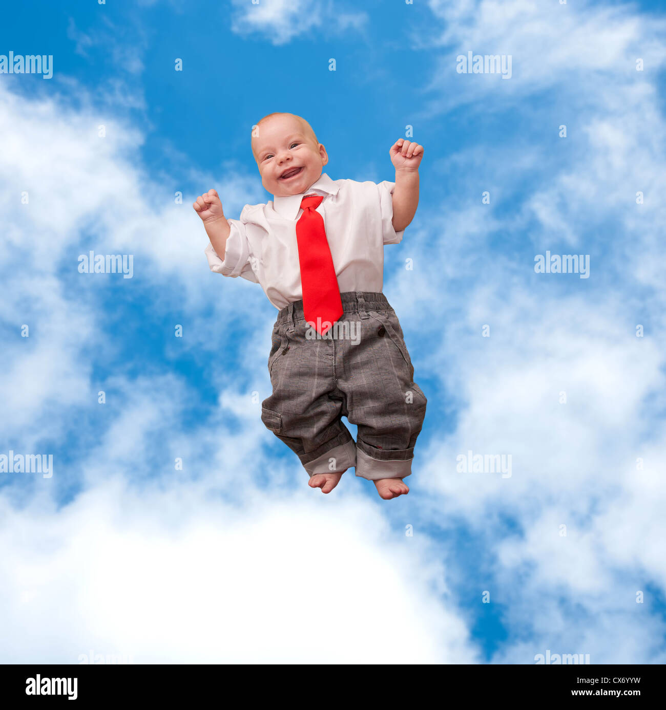 Tiny newborn baby smiling flying up into the sky and clouds. Kid ...