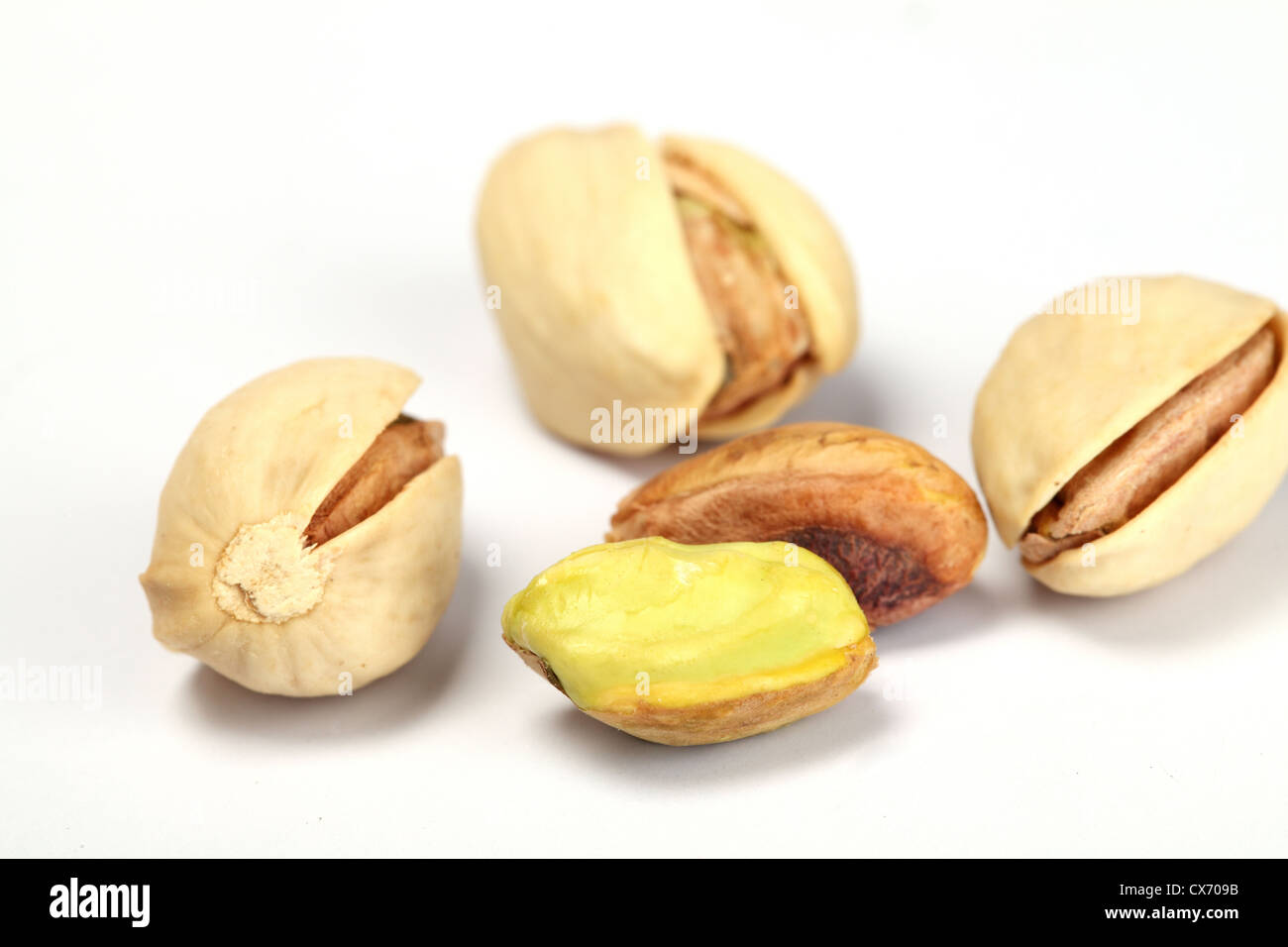 Roasted pistachios spilled on white background Stock Photo - Alamy